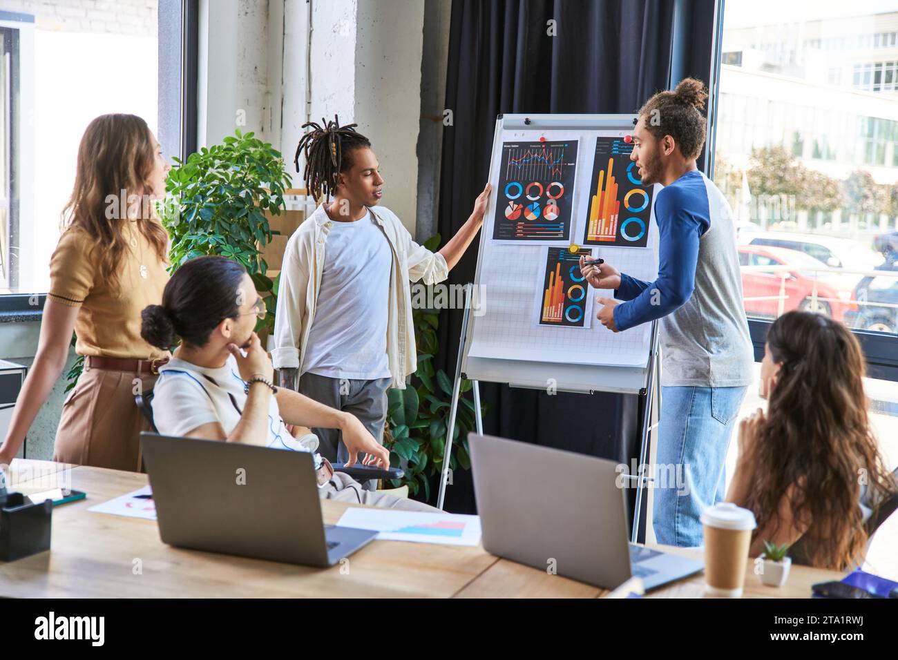 multicultural colleagues discussing startup project near flip chart ...