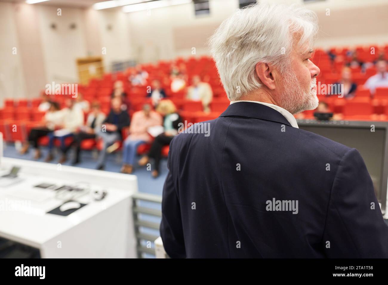 Rear view of male speaker at stage during business conference in ...
