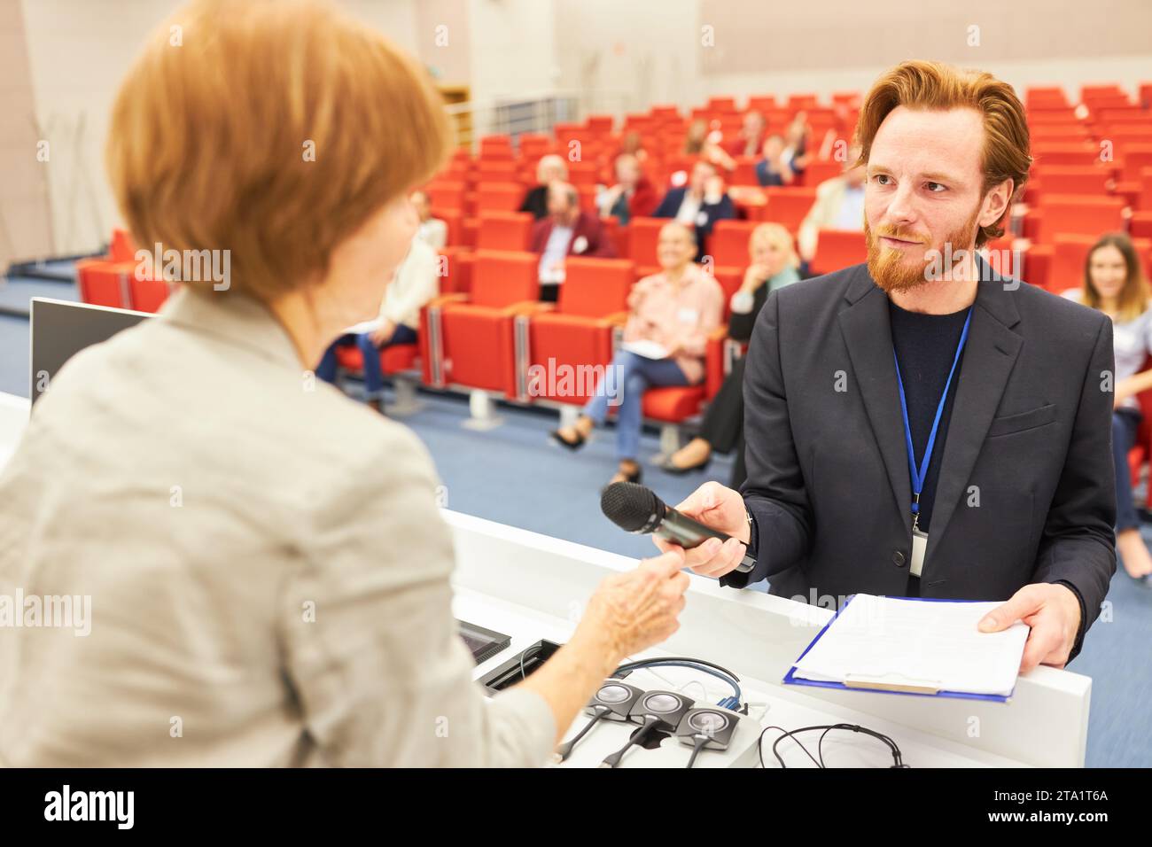 Male professional with microphone asking question to speaker during ...