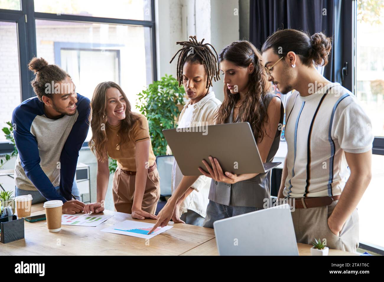 female team lead with laptop pointing at graphs on meeting with ...