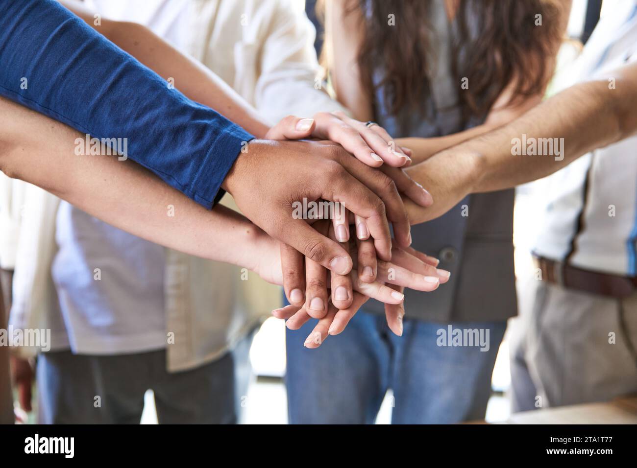 cropped view of multiethnic people joining hands as sign of unity ...