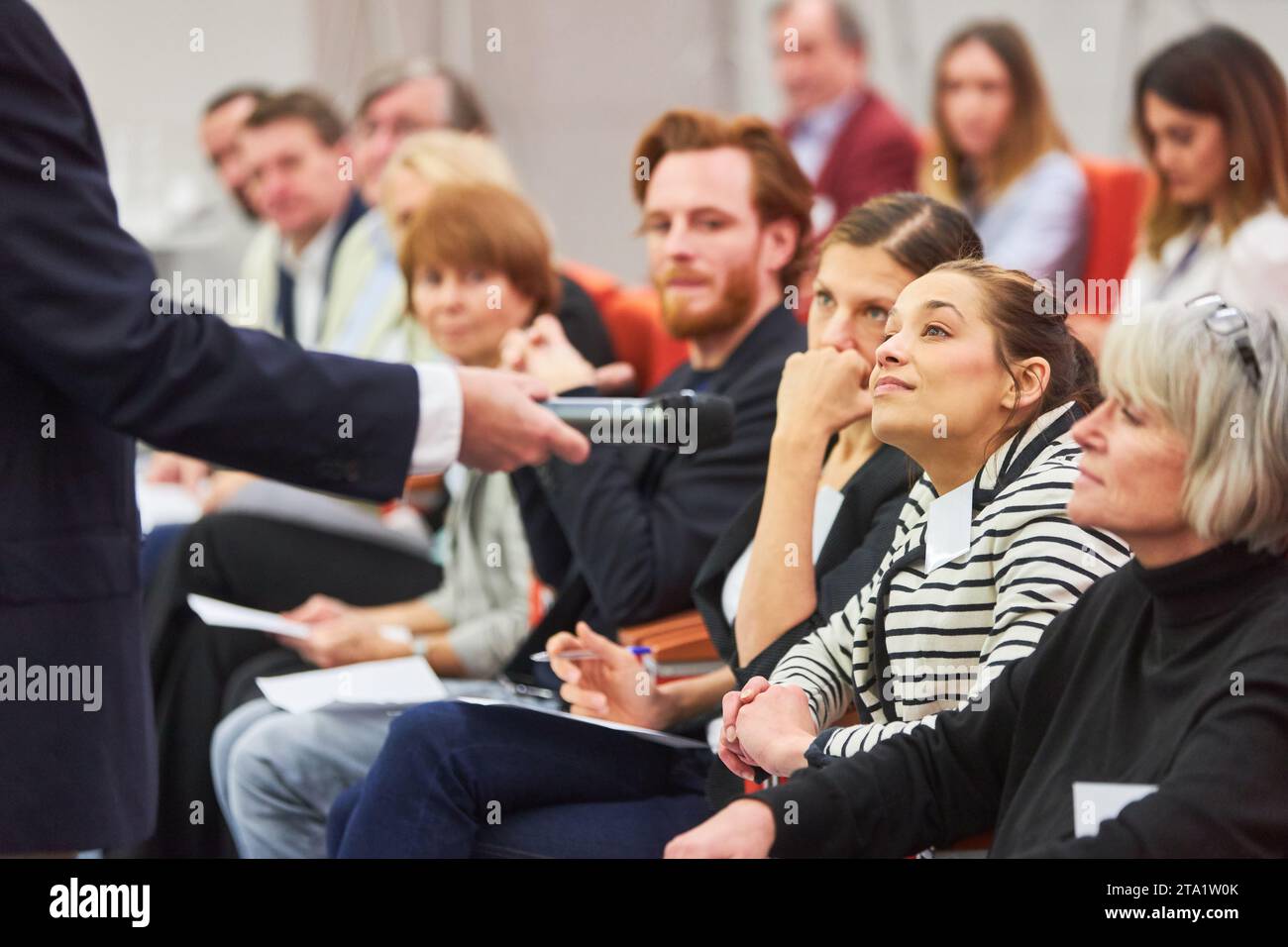 Professional asking question to businesswoman during conference in ...