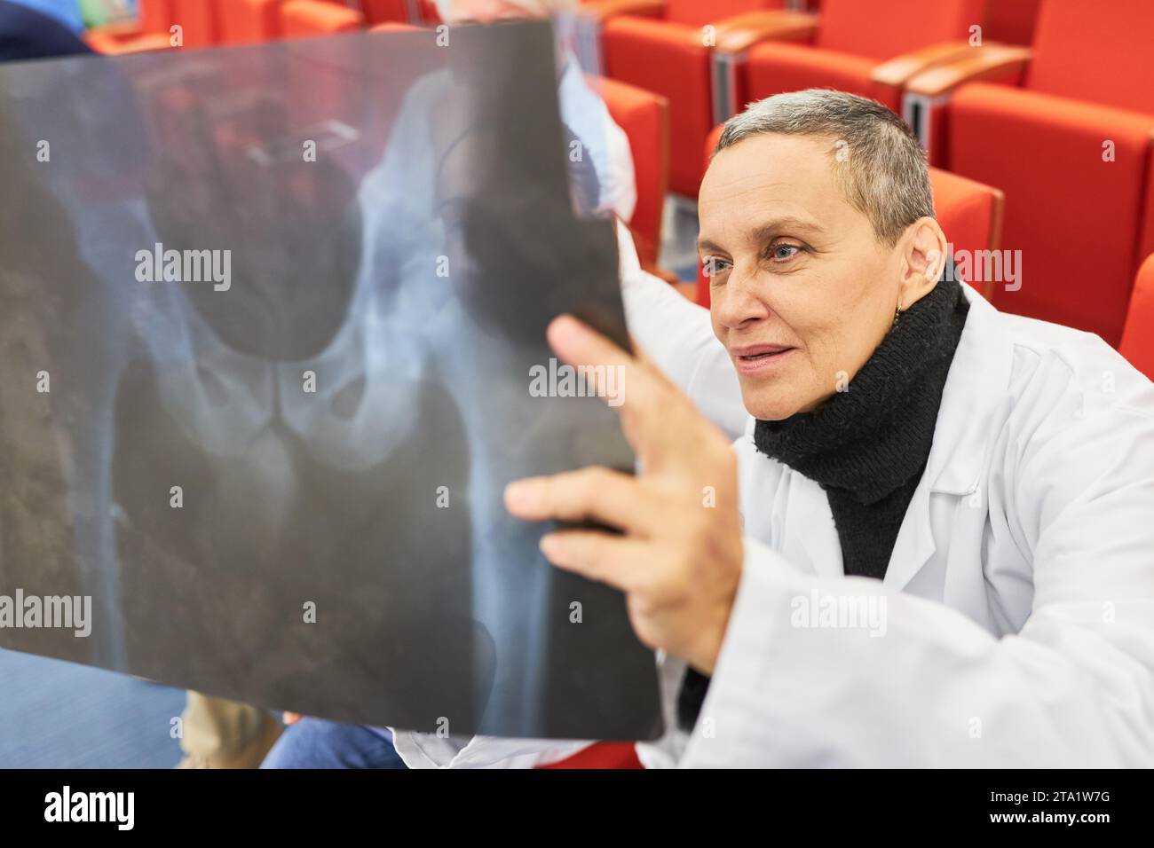 Female doctors in audience of medical conference examining medical x ...