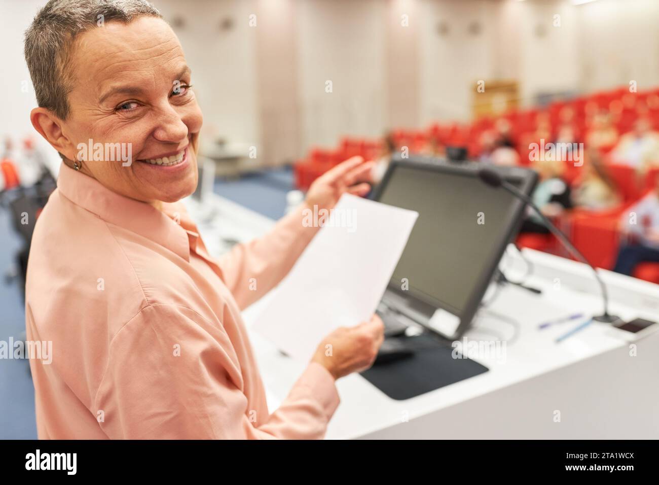 Portrait of female speaker holding document at business conference ...