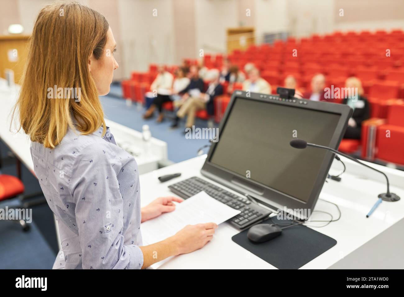 Female speaker with microphone on panel at business conference talking ...