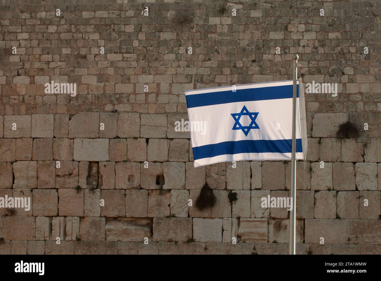 A large blue and white flag of the State of Israel fully outstretched ...
