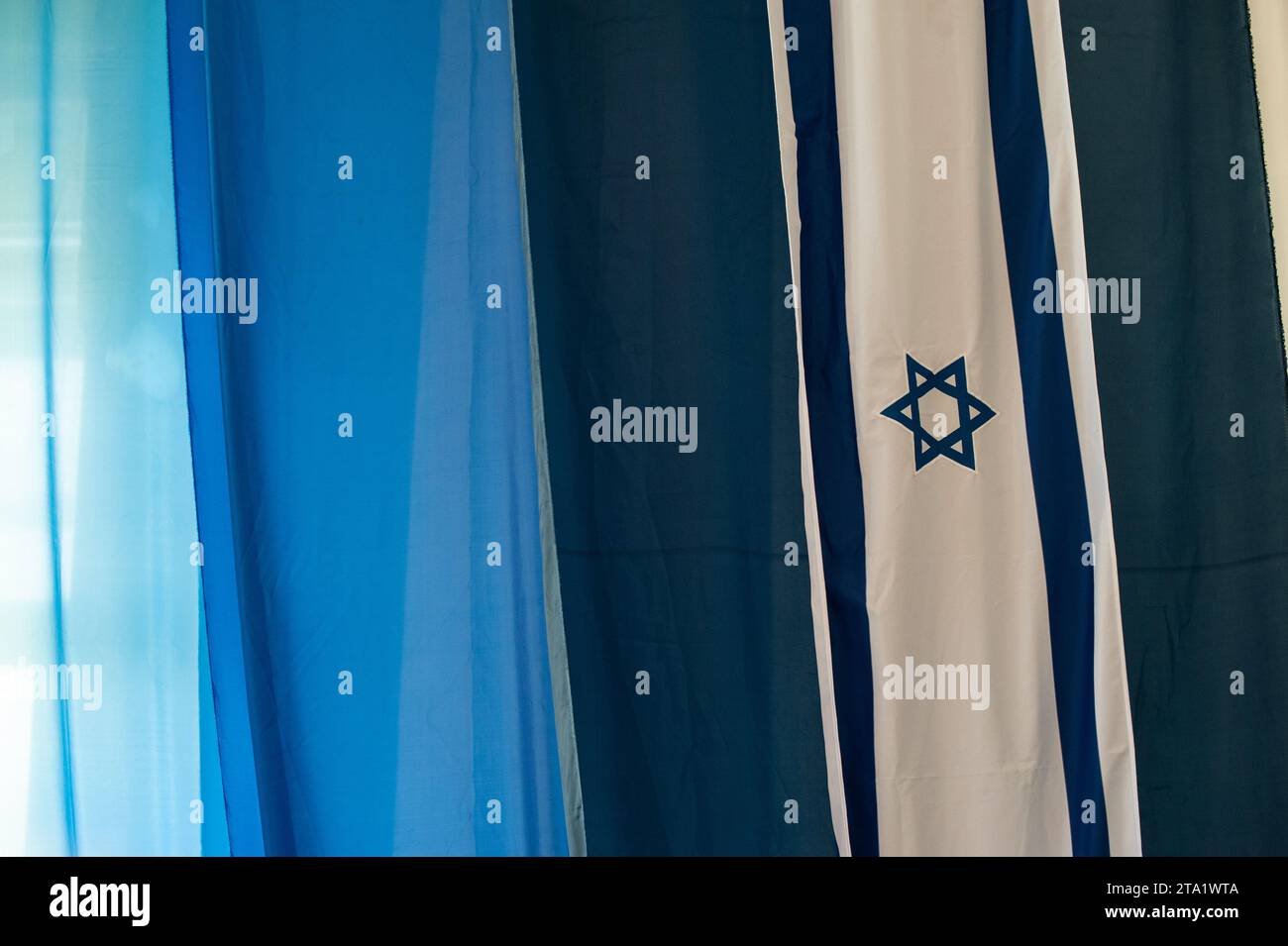 A long, vertical, blue and white flag of the State of Israel on a ...