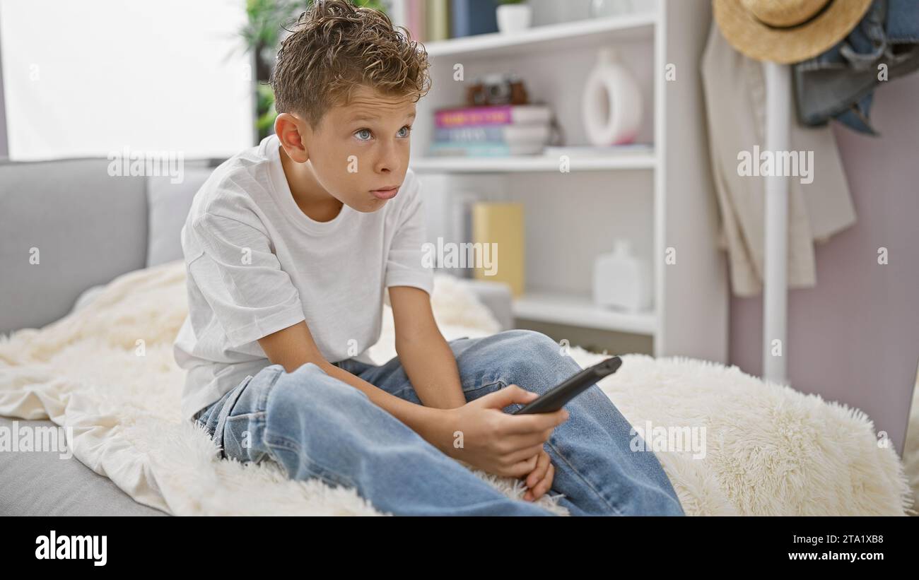 Adorable blond kid wearing a bored expression, comfortably hustling on ...