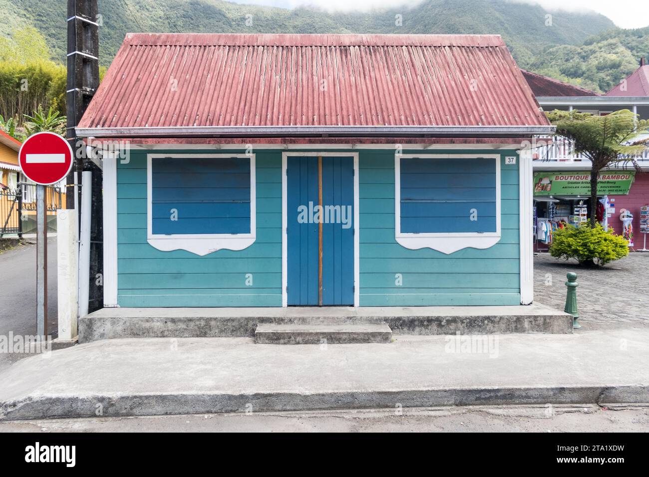 Turquoise house with blue shutters and a sienna-colored tin roof in the ...