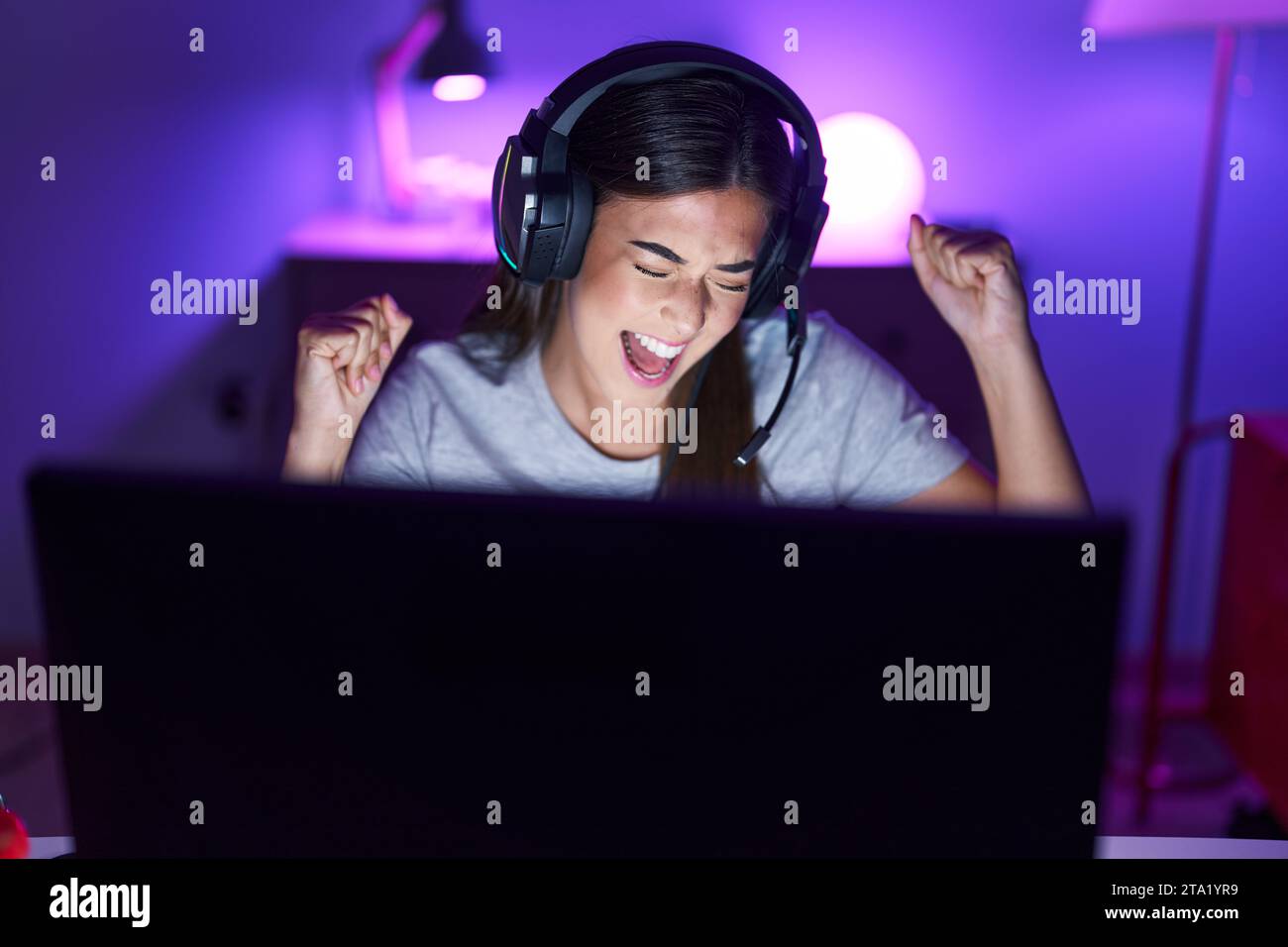 Young beautiful hispanic woman streamer playing video game with winner ...