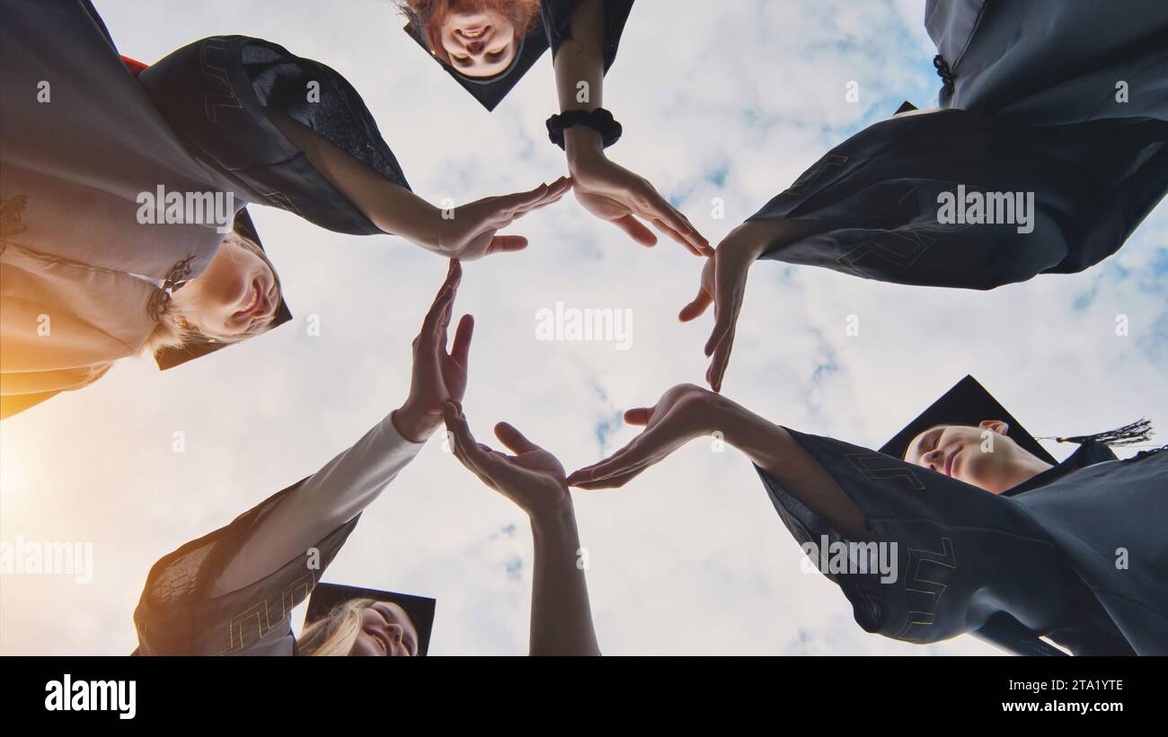 College graduates make a circle of their hands Stock Photo - Alamy