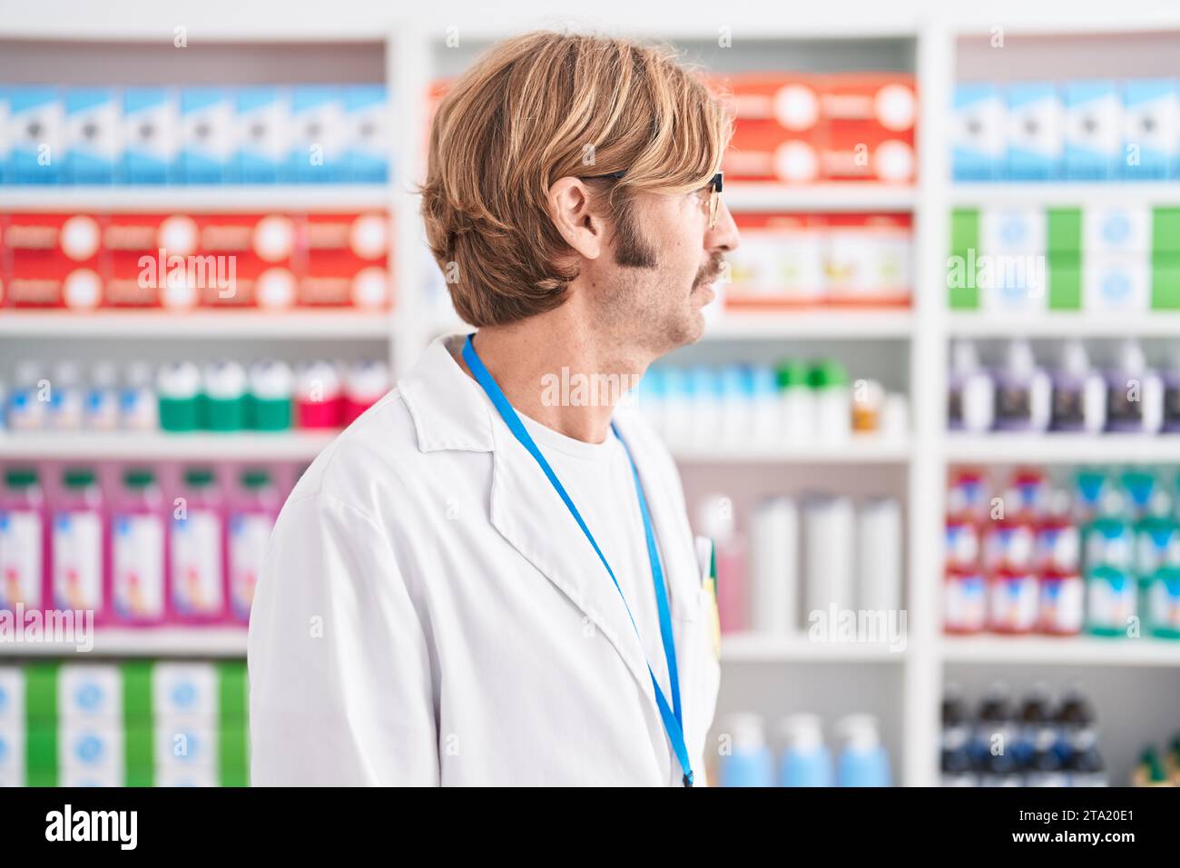 Caucasian man with mustache working at pharmacy drugstore looking to ...