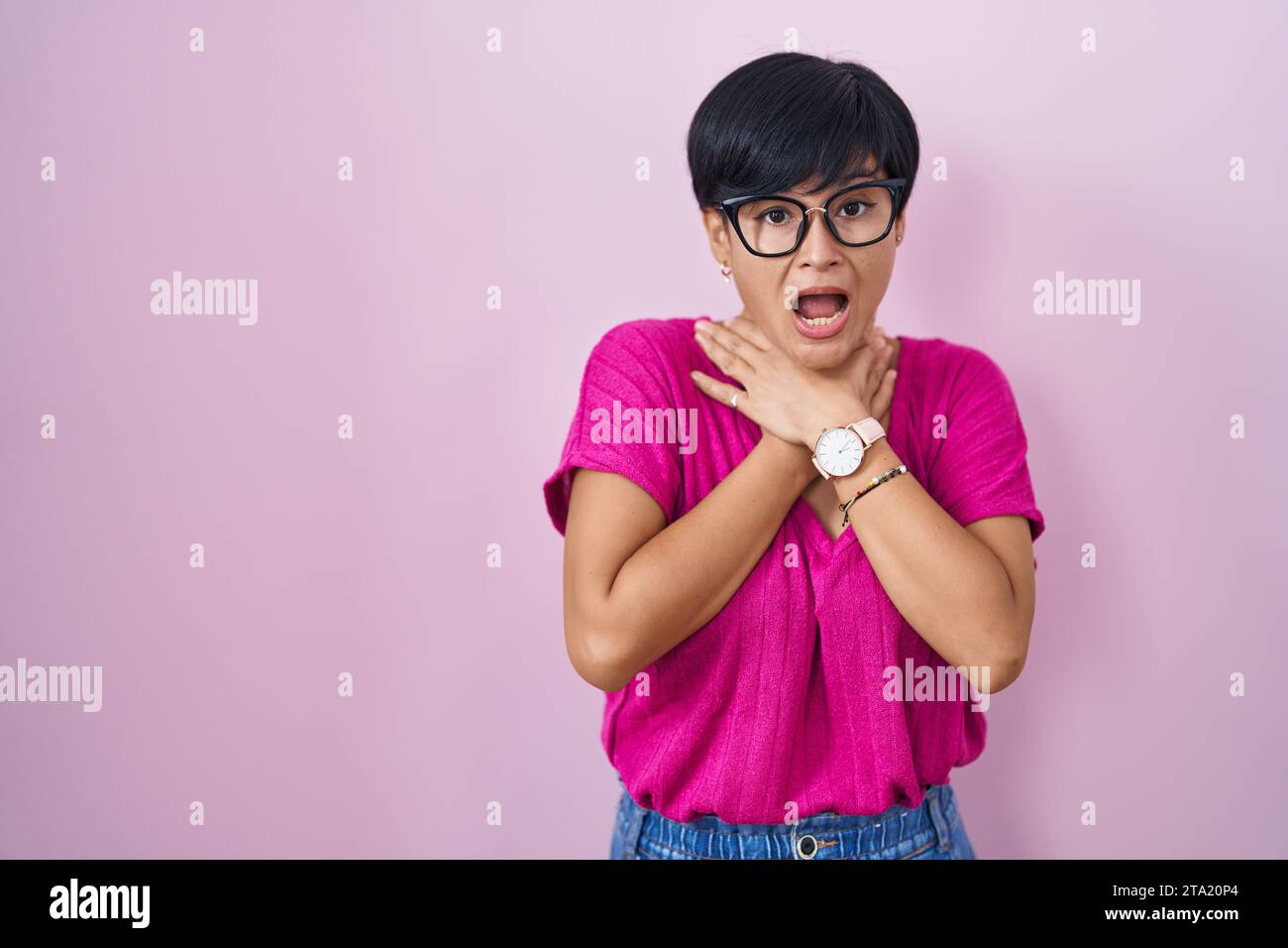 Young asian woman with short hair standing over pink background ...