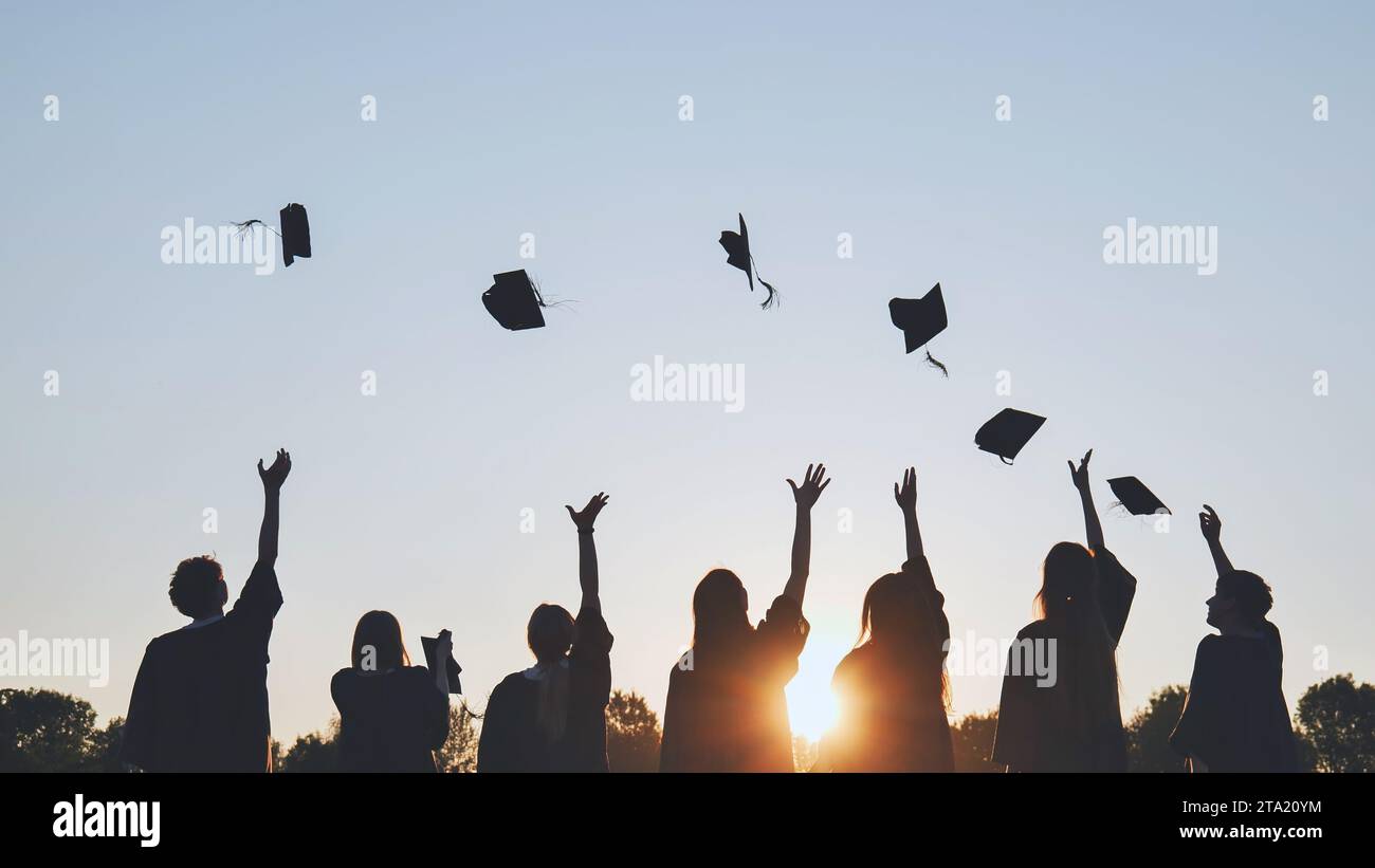 Silhouettes of Happy college graduates tossing their caps up at sunset ...