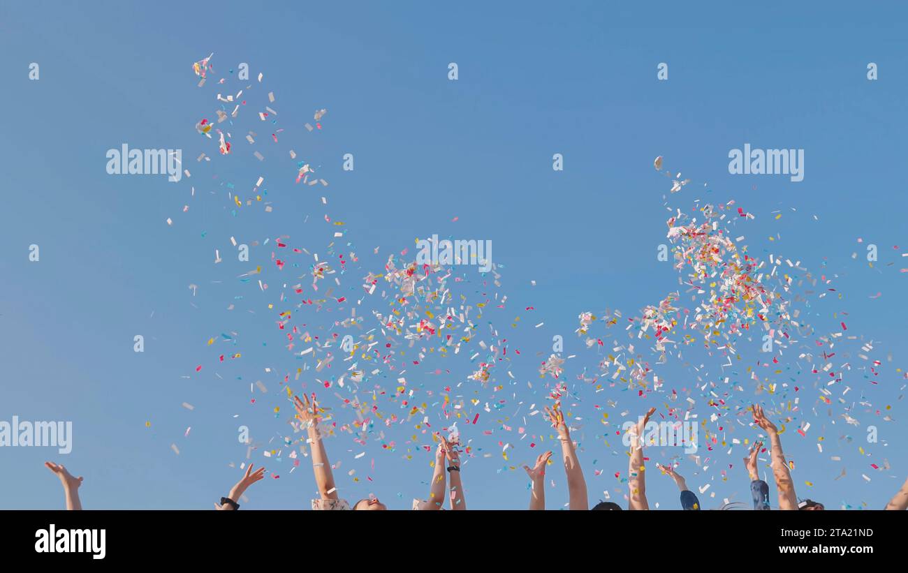 Tossing colorful paper confetti from the hands of young people Stock ...
