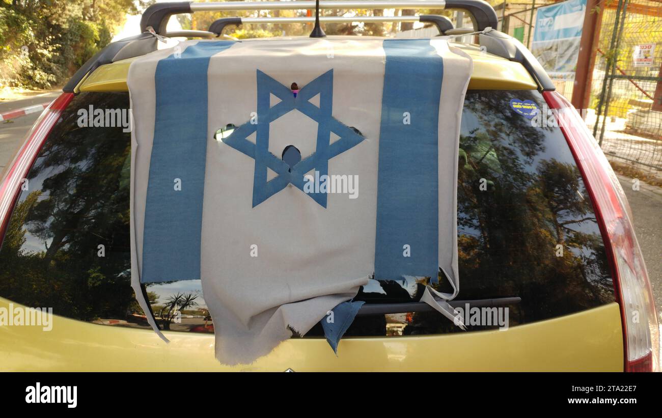 An old, torn, weathered blue and white flag of the State of Israel ...