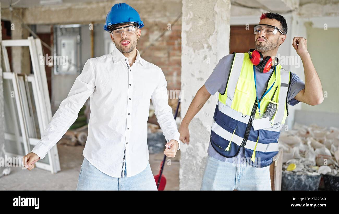 Two men builder and architect smiling confident dancing at construction ...
