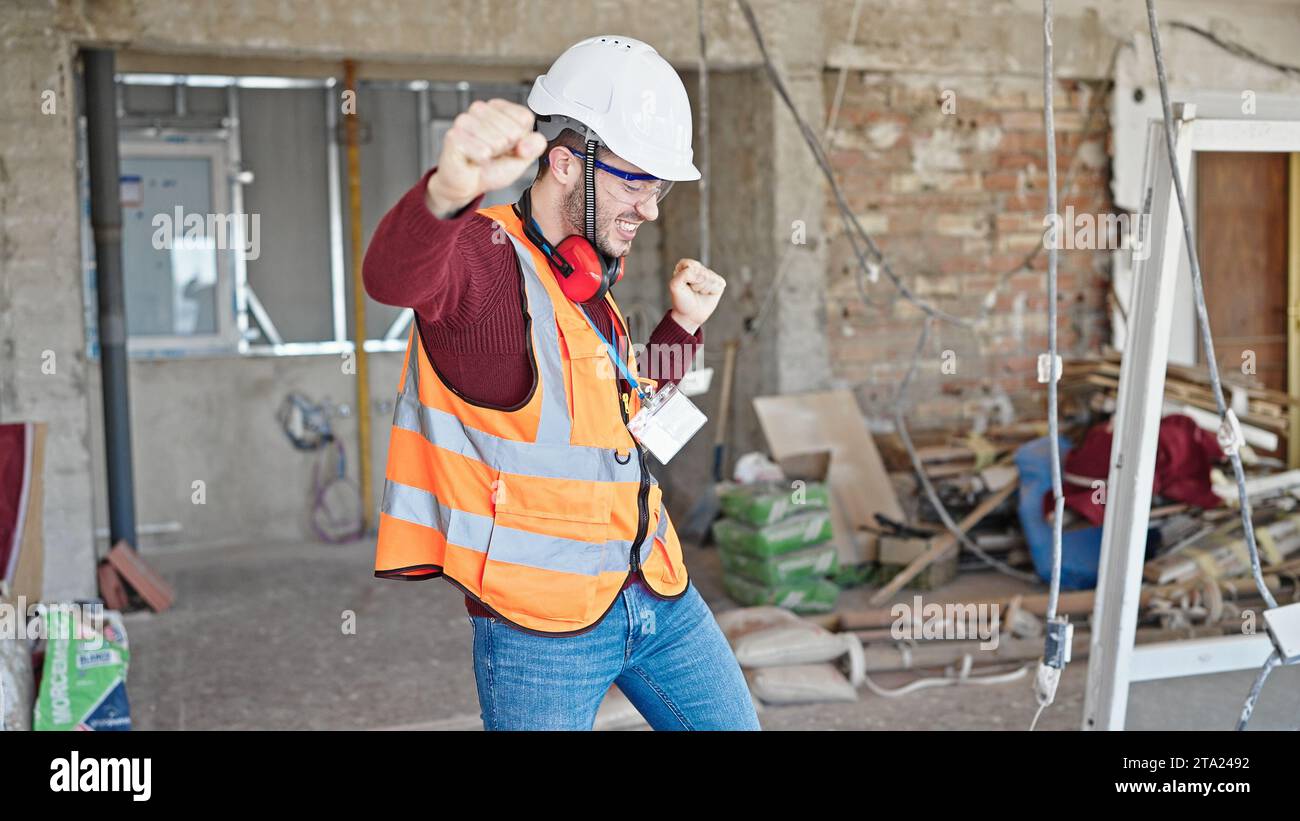 Young hispanic man builder smiling confident dancing at construction ...