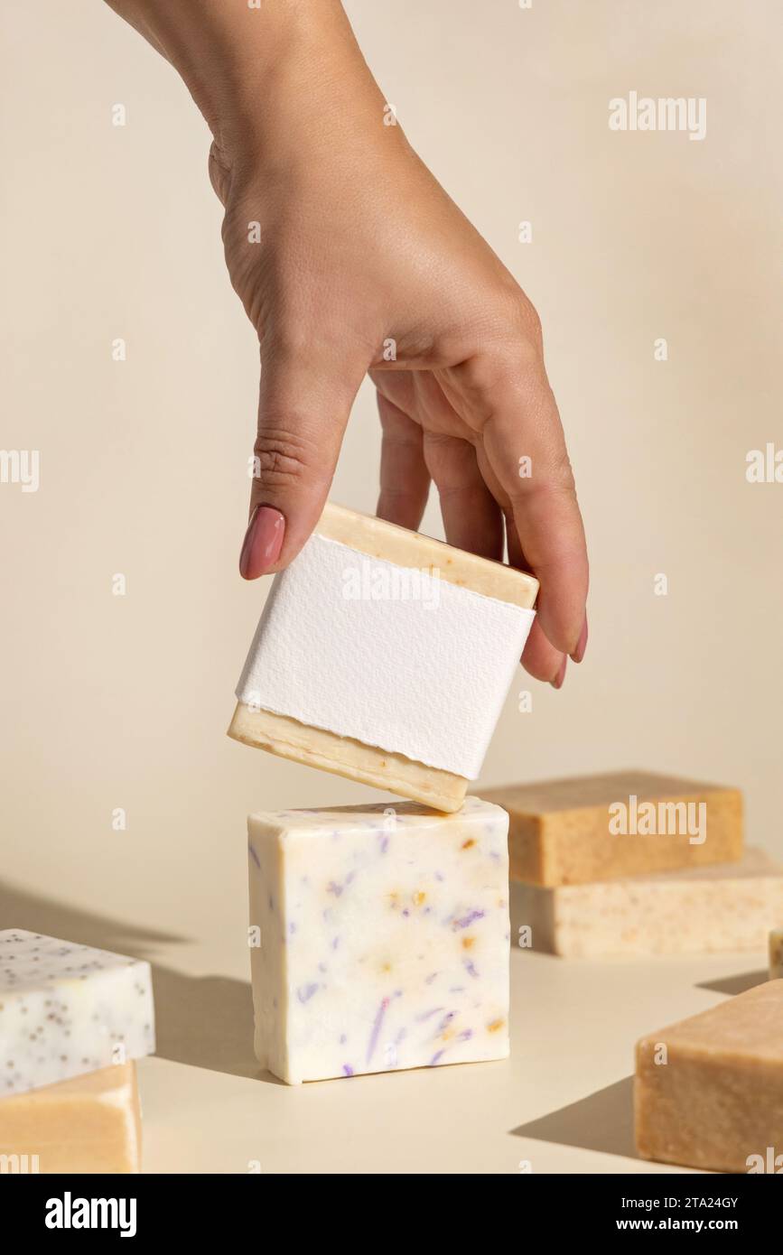 Hand keeps natural beige soap bars with blank label on light beige ...
