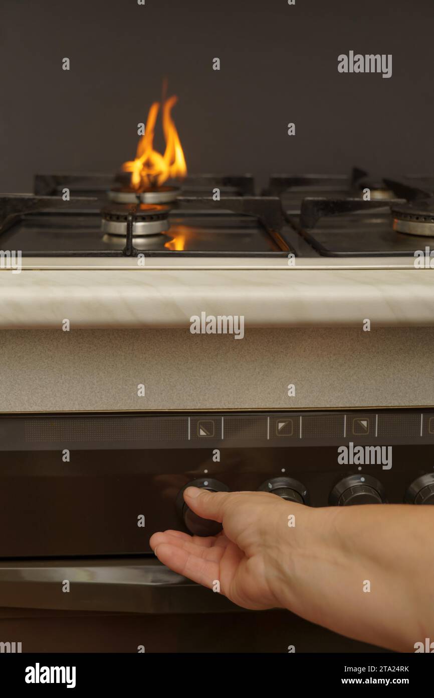 Woman's hand turning on the gas on her kitchen stove energy cost ...