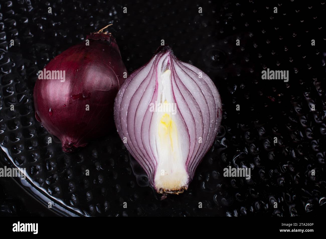 Red onion bulb cut in half on a certain background Stock Photo - Alamy