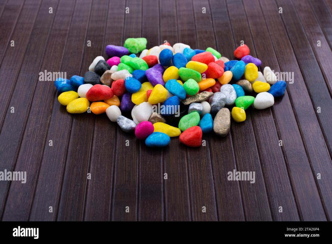 Pile of little colorful pebbles on wooden background Stock Photo - Alamy