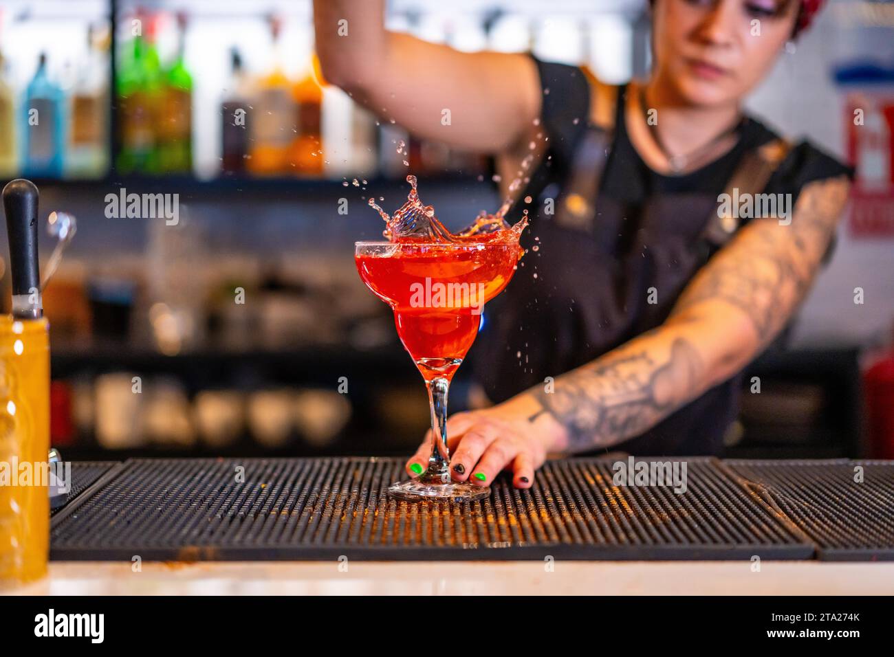 Cocktail splashing while a bartender mixing ingredients in the counter of a bar Stock Photo - Alamy