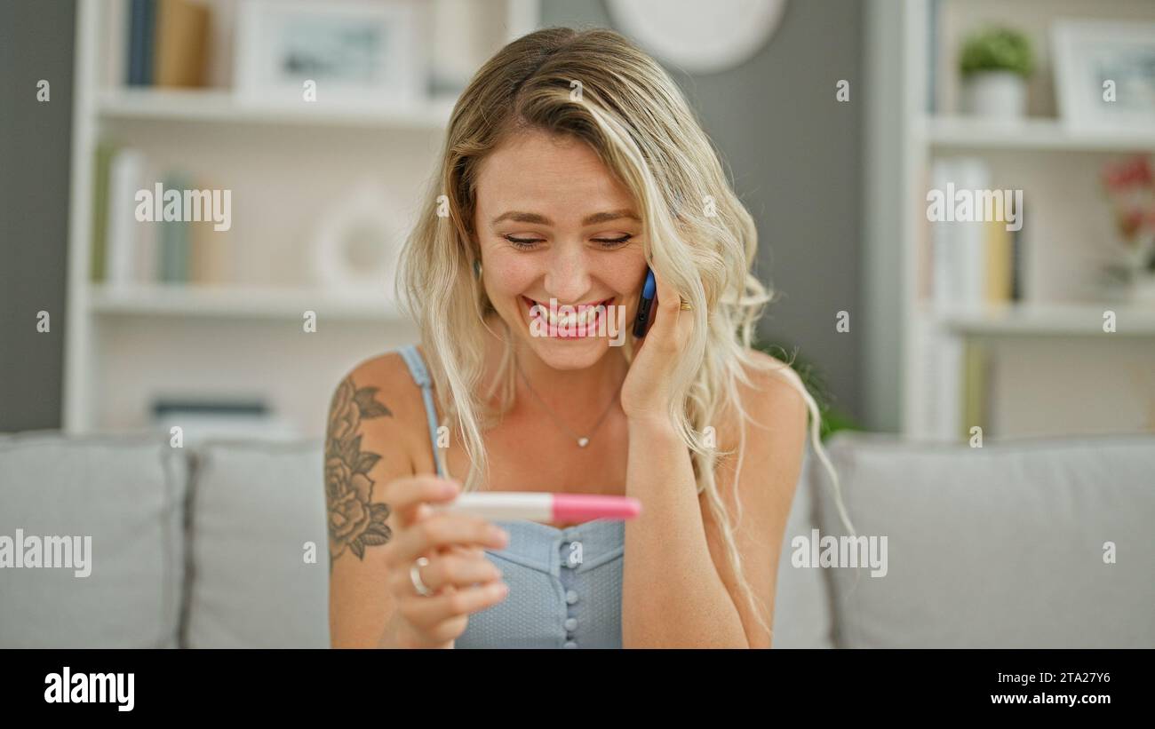 Young blonde woman holding pregnancy test crying at home Stock Photo ...