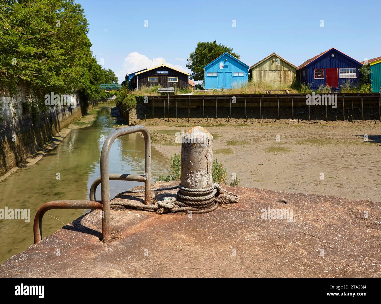 Colourful houses and a jetty with bollards at low tide in Le Chateau-d ...