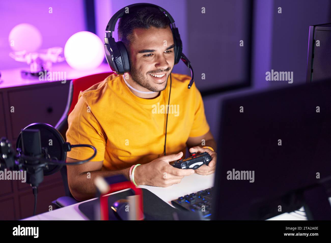 Young hispanic man streamer playing video game using joystick at gaming ...