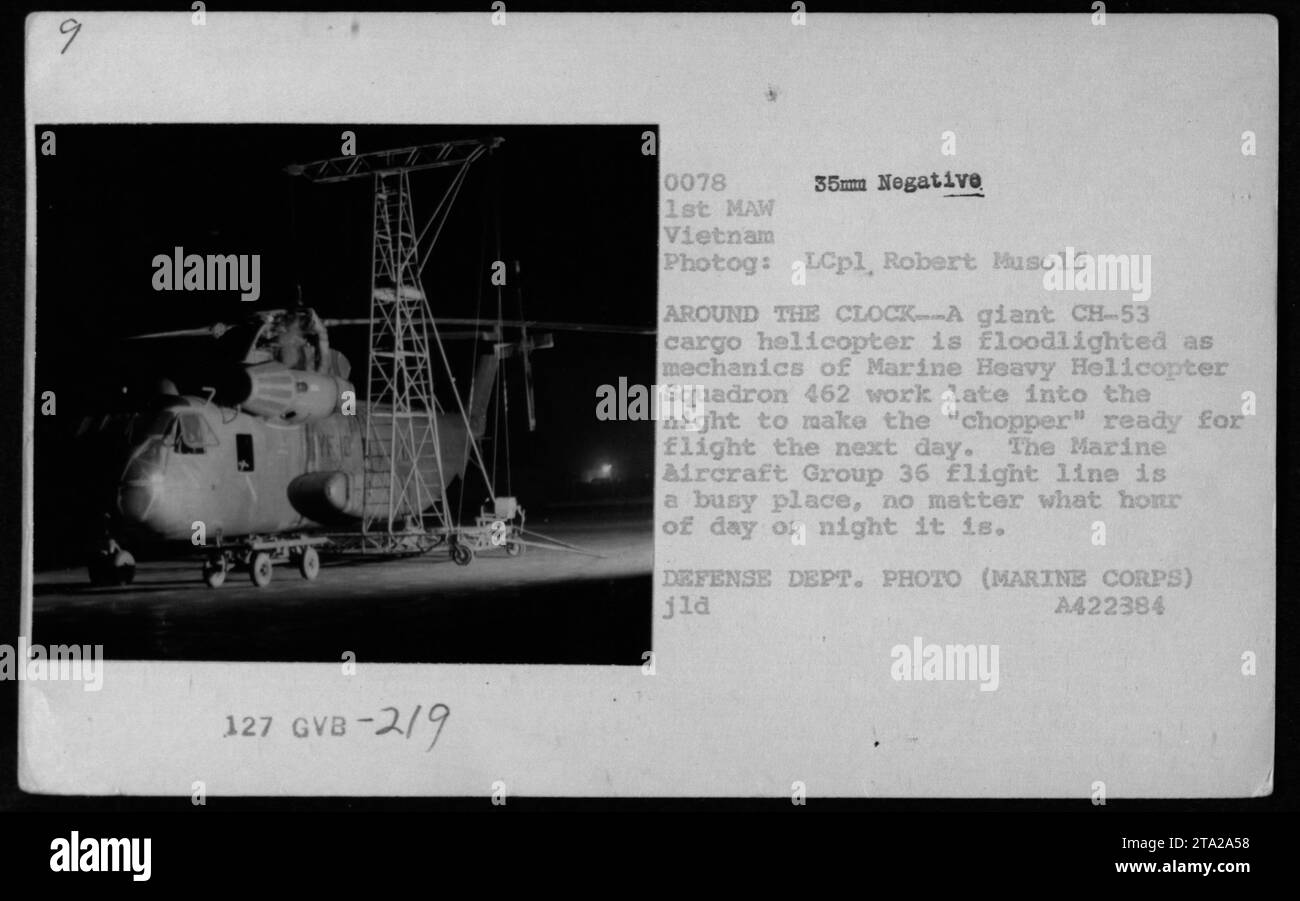 A CH-53 cargo helicopter is being worked on by mechanics of Marine ...