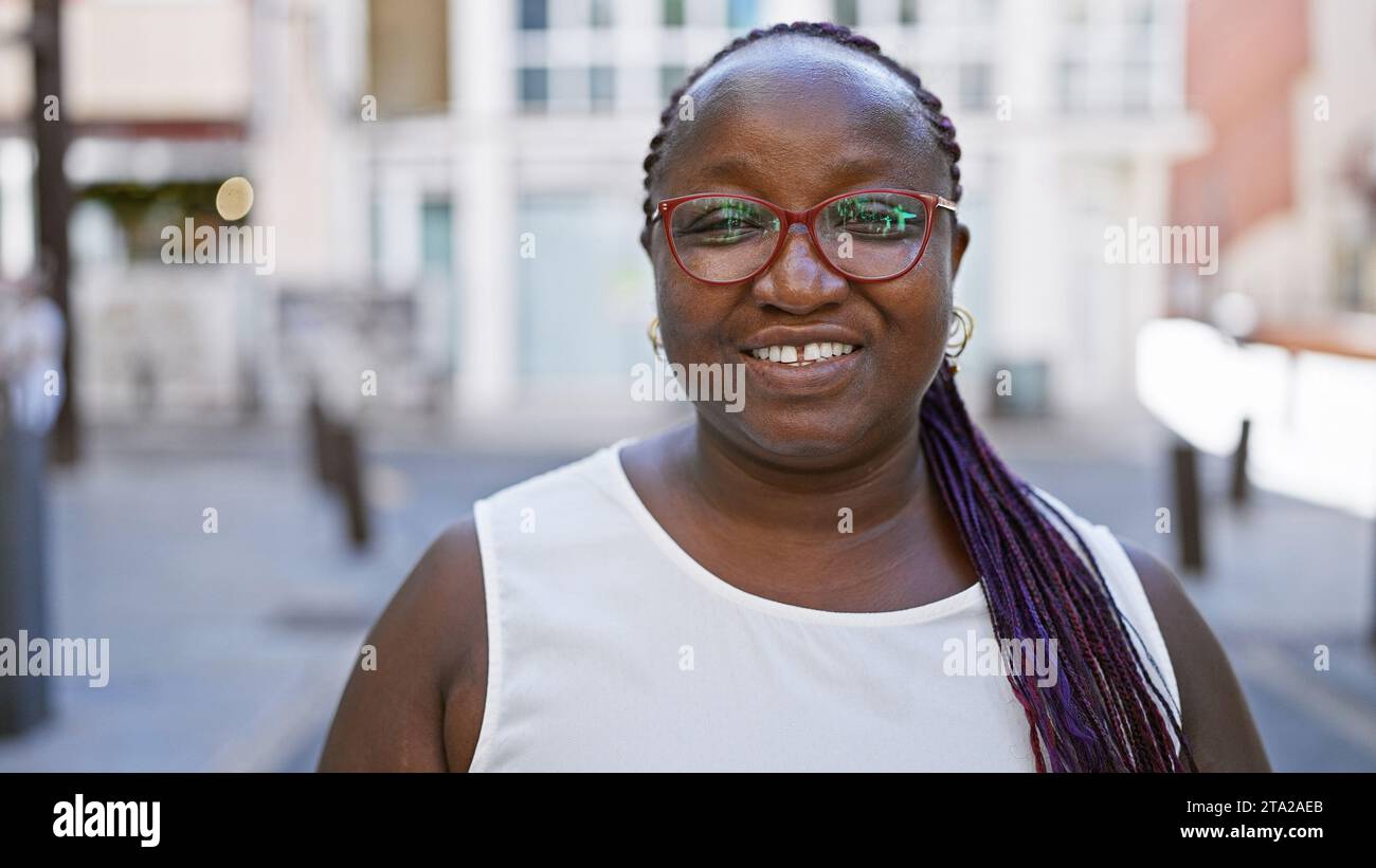 Confident african american woman standing on urban street, radiating ...
