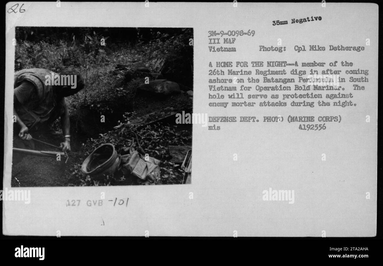 A Marine from the 26th Marine Regiment digs a trench upon arriving at ...