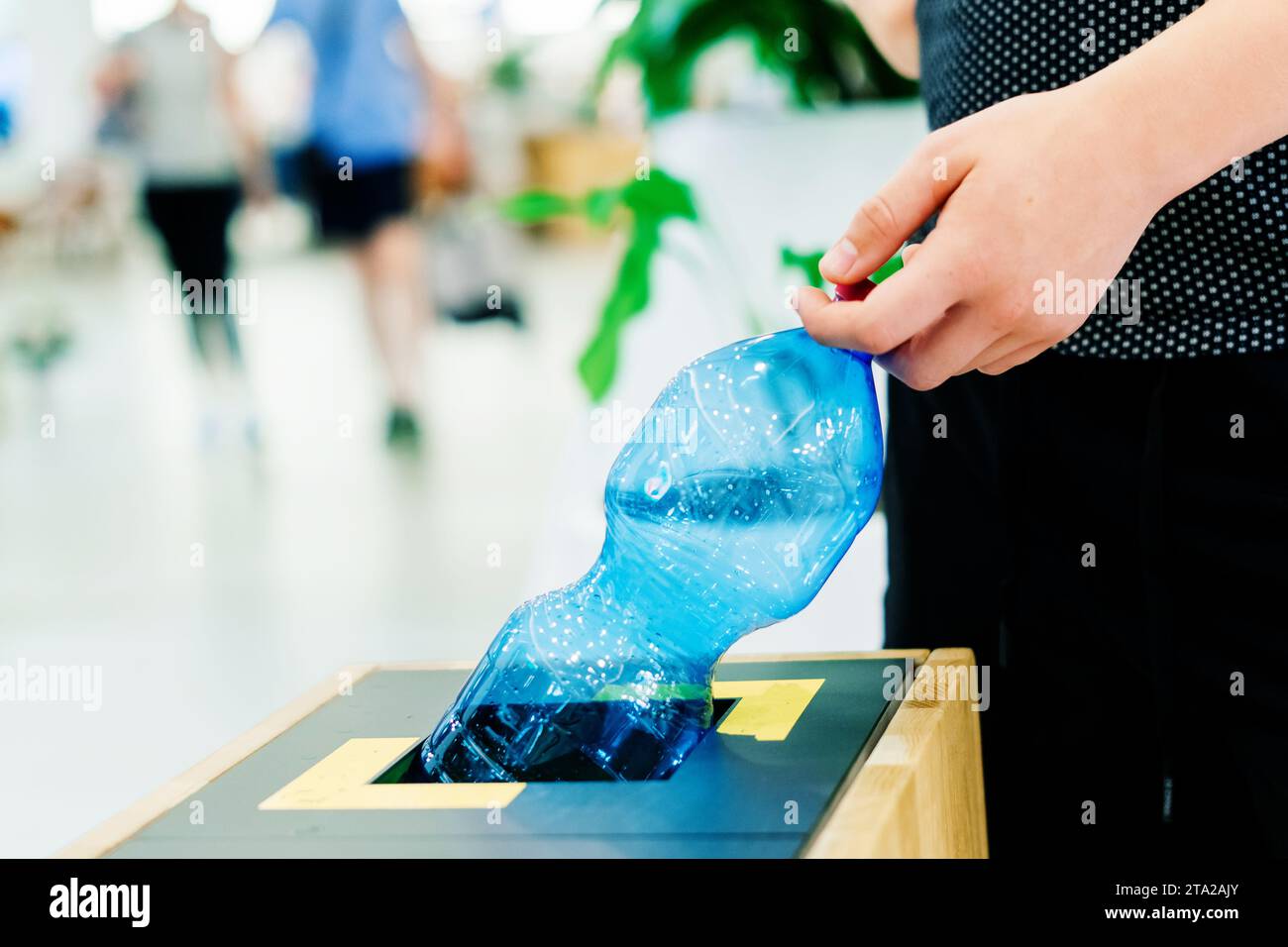 Selective focus close up hand throwing an empty plastic bottle in the recycling garbage trash or ...