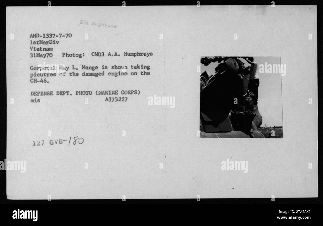 Corporal Ray L. Mange takes pictures of damaged engine on a CH-46 ...