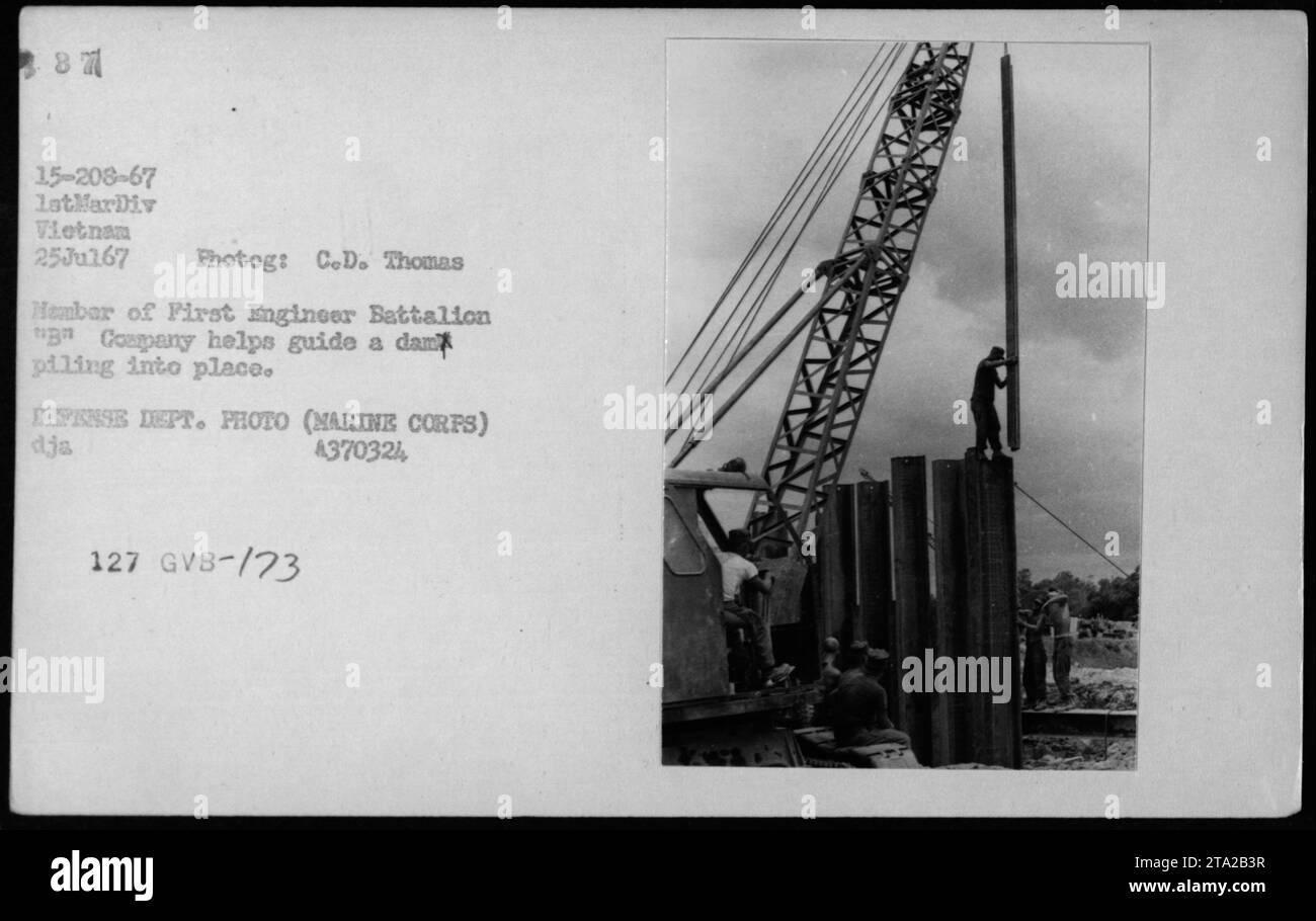 A member of B Company, First Engineer Battalion assists in the ...