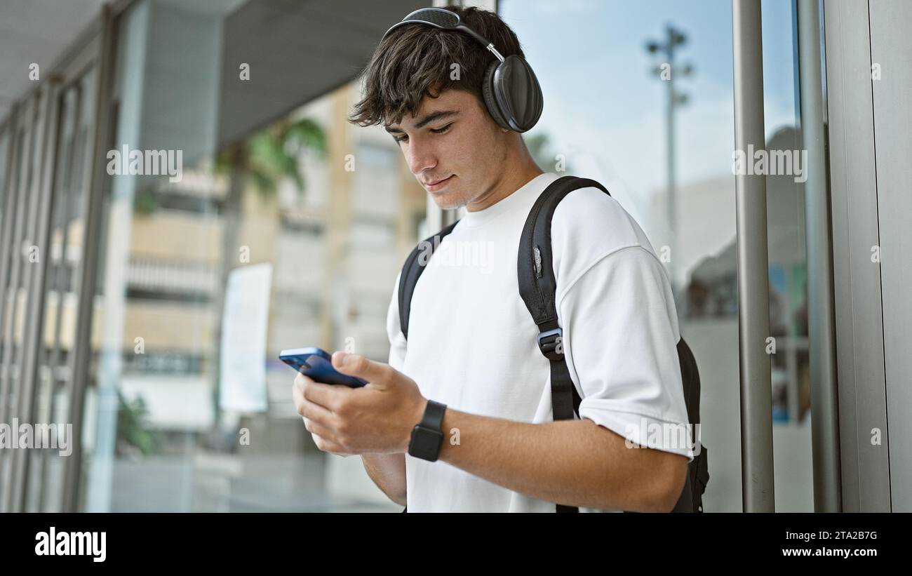 Cool young hispanic guy, a serious university student, vibing to music ...