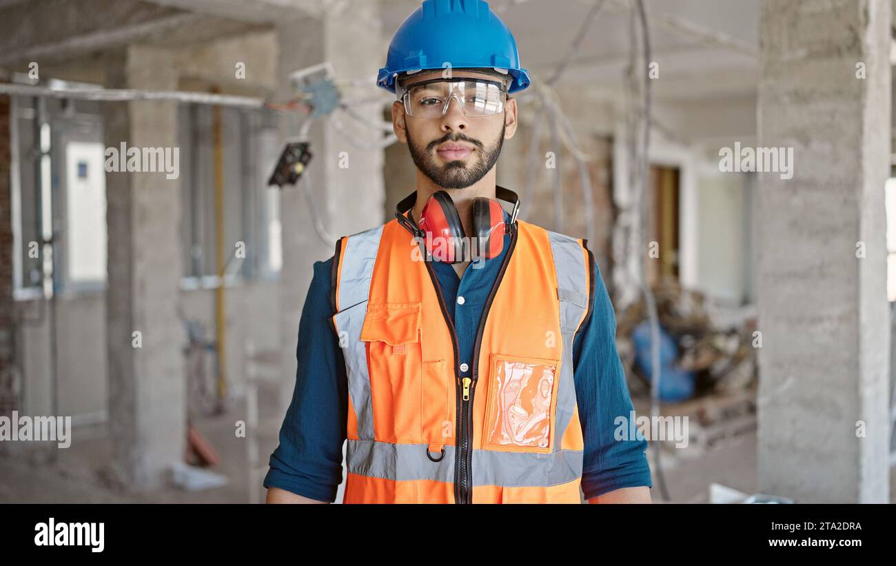 Young hispanic man builder wearing hardhat at construction site Stock ...