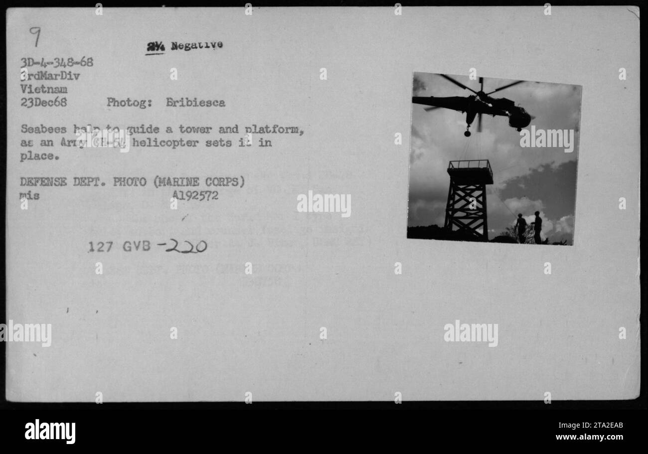 On December 23, 1968, Seabees guide a tower and platform into place as ...