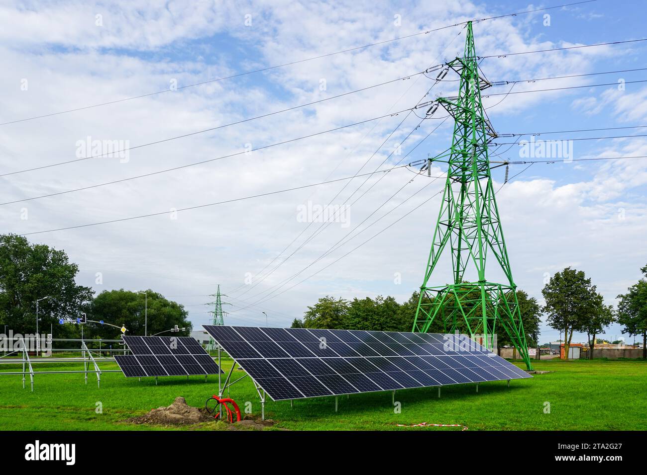 Installation of solar panels on metal frames in a green meadow near ...