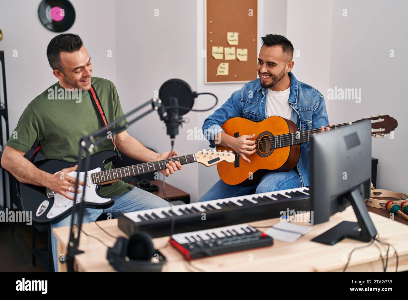 Two men musicians playing classical and electrical guitar at music ...