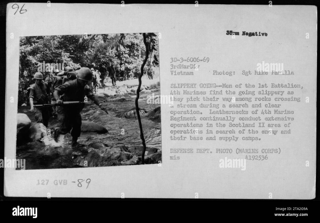 Soldiers of the 1st Battalion, 4th Marines move through a rocky stream ...