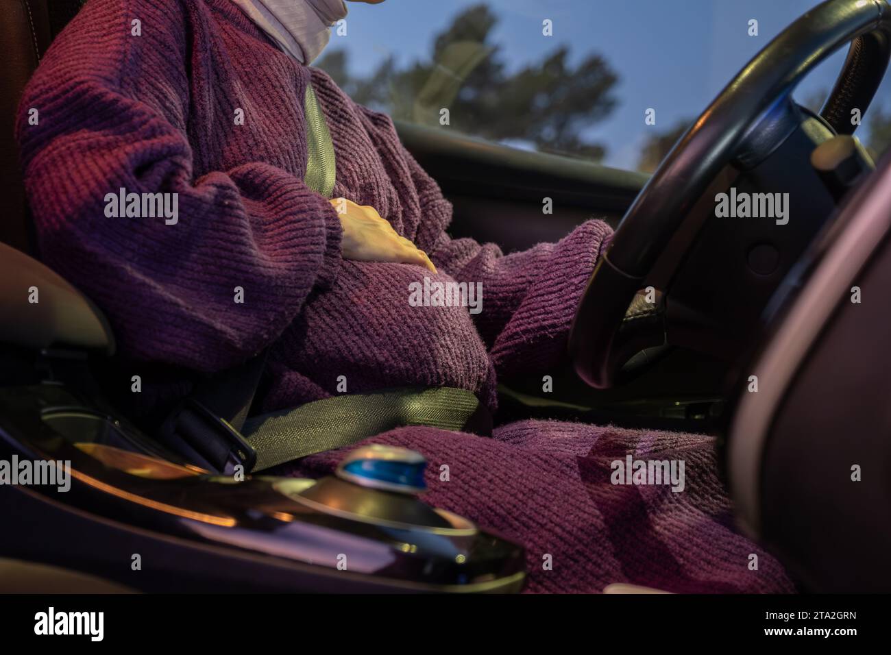 Pregnant arabic muslim woman driving car at night wearing winter ...