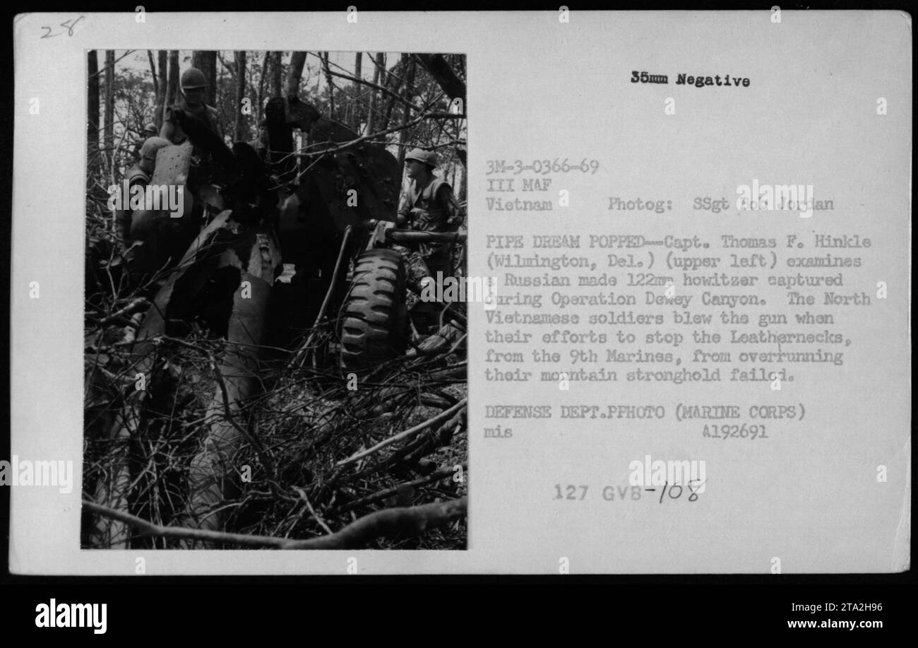 Captain Thomas F. Hinkle inspects a captured Russian 122mm howitzer ...