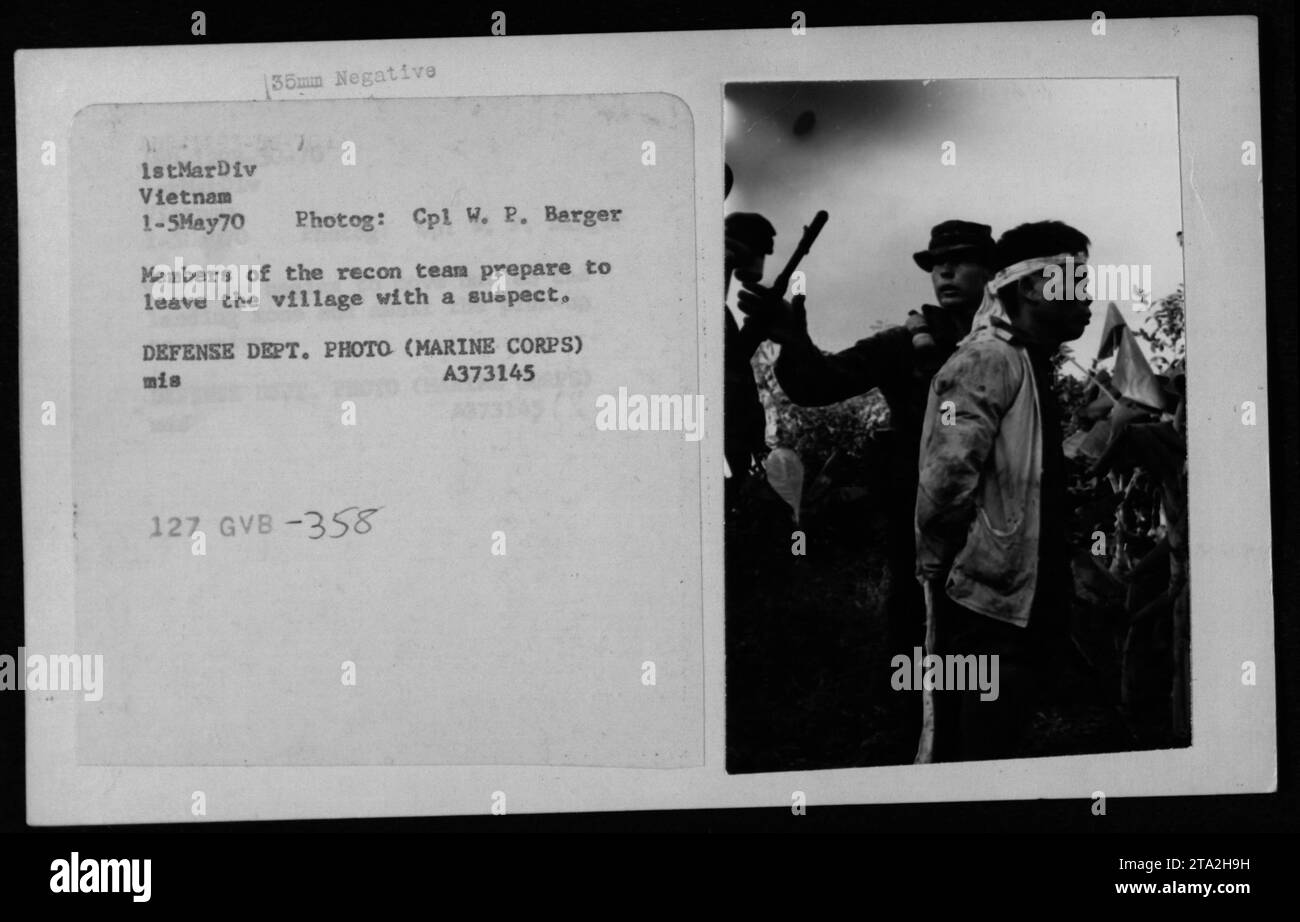 U.S. Marines depart a Vietnamese village with a captured Viet Cong ...