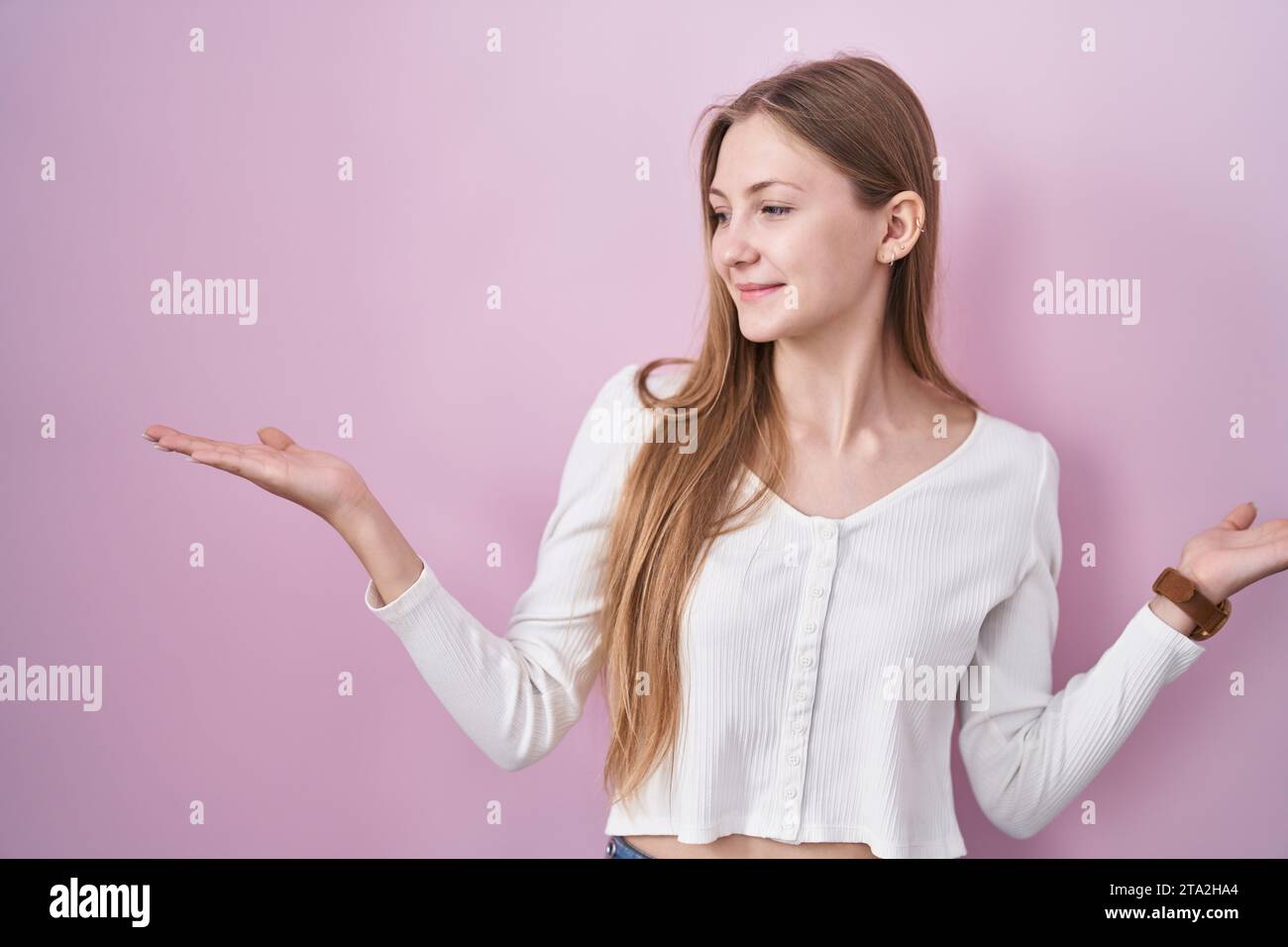 Young caucasian woman standing over pink background smiling showing ...