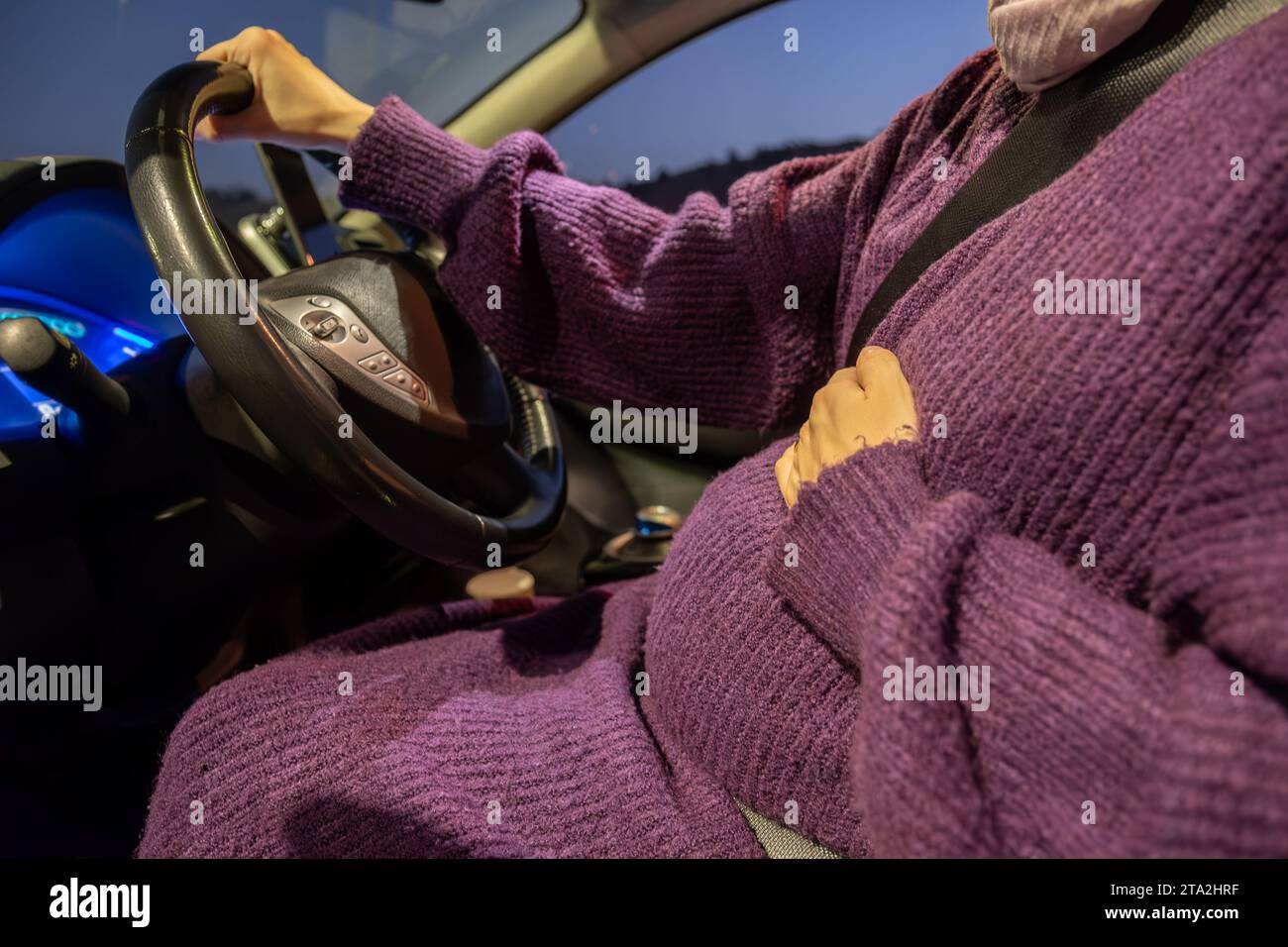 Pregnant arabic muslim woman driving car at night wearing winter ...