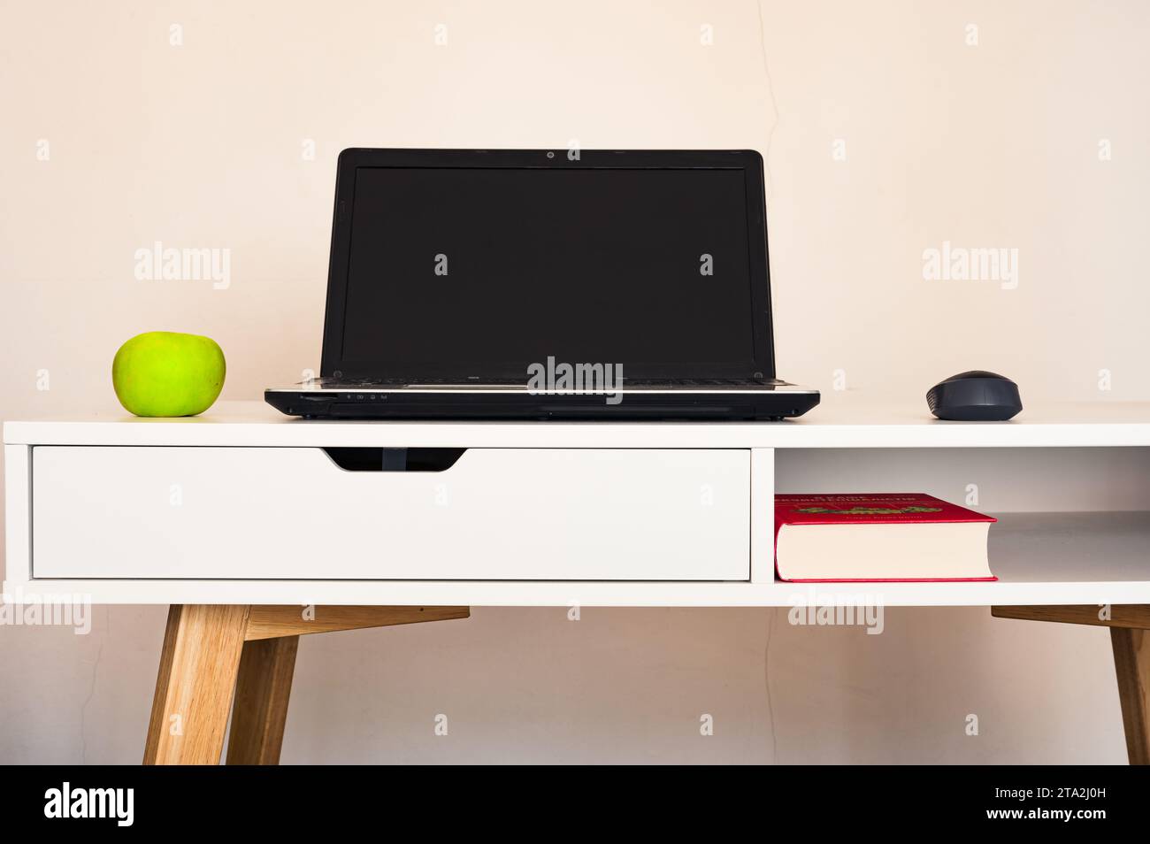Empty open laptop with mockup and black screen on white desk table ...