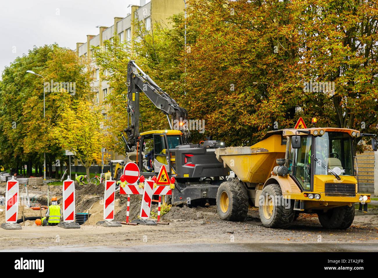 City street rebuilding view, hydraulic excavator, yellow dump truck ...
