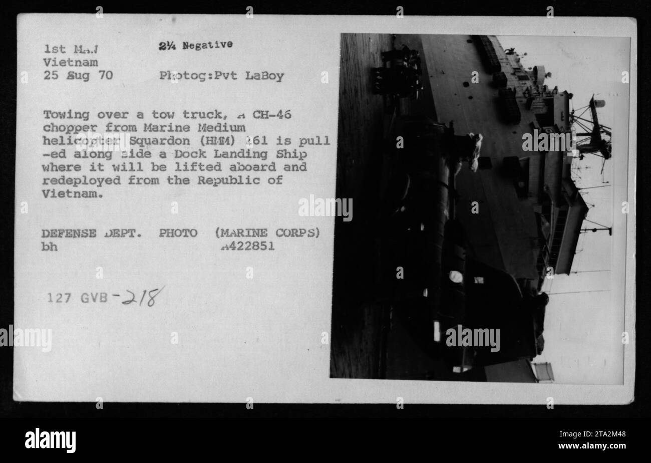 A CH-46 helicopter of HMM-161 is towed near a Dock Landing Ship in ...